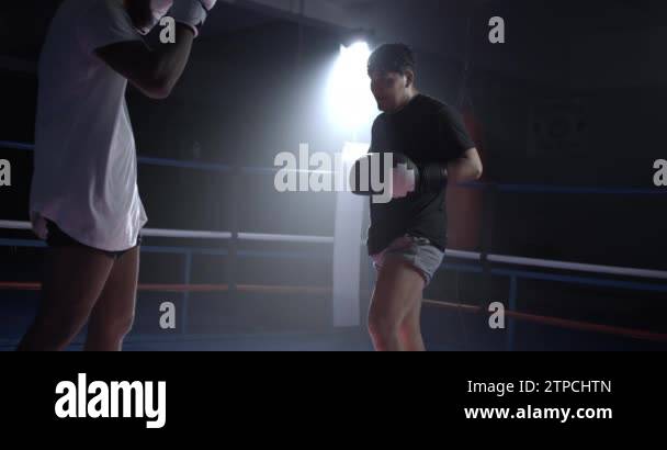 Two fighters facing each other inside boxing ring in dramatic slow ...