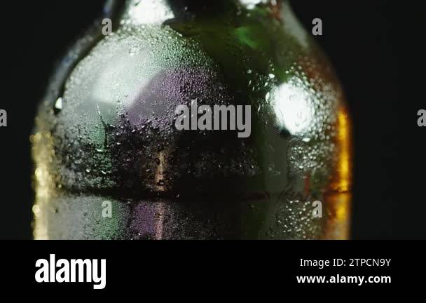 A glass bottle of cold beer. Condensate droplets appeared on the ...