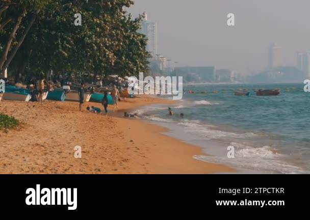 Coastline of the beach. People bathe in the sea, water rides, wave beat on the sandy shore ...