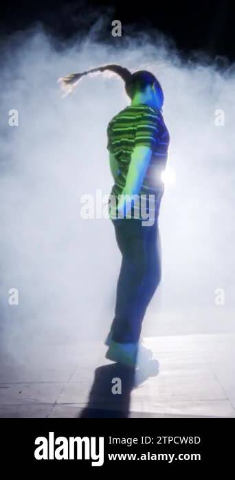 Dancer performing hip hop dance in slow motion with light and smoke ...