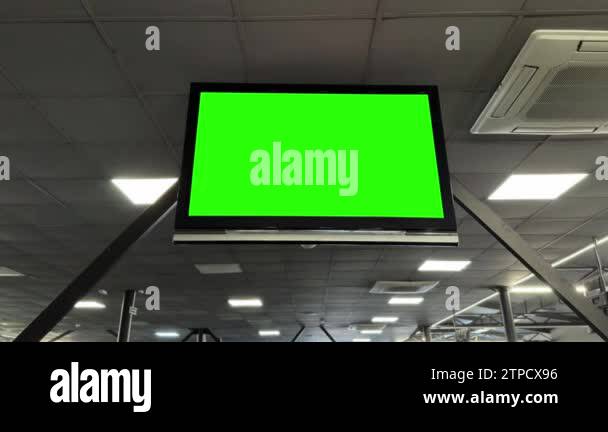 Chromakey green screen on a flat-screen TV, ceiling-mounted in a gym ...