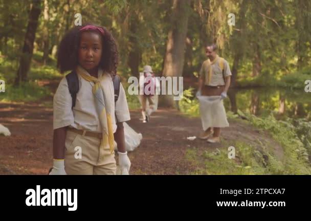 Medium portrait of little African American girl scout posing for camera ...
