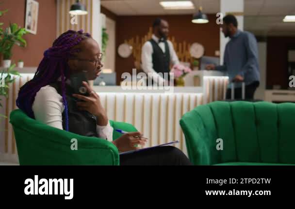 Worker managing bookings by phone, answering calls to register to ...