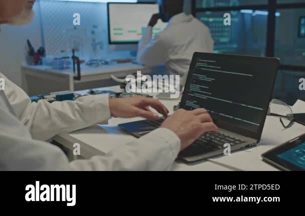 Waist up of mature Caucasian male electronics engineer program coding ...