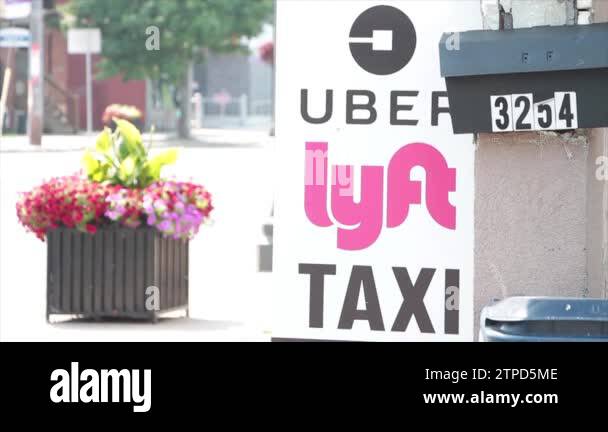 uber lyft taxi vertical sign logos writing text next mailbox and road ...