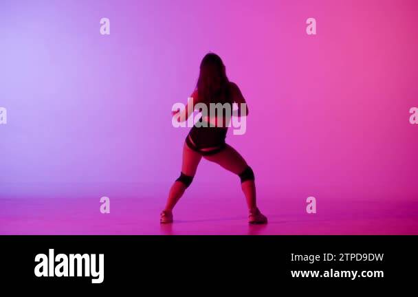 In the frame on a color background dances young slim woman, she is ...