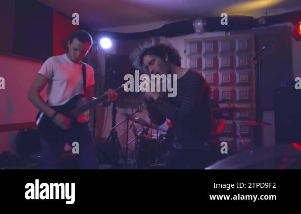 The frontman of a musical rock band sings emotionally into the ...