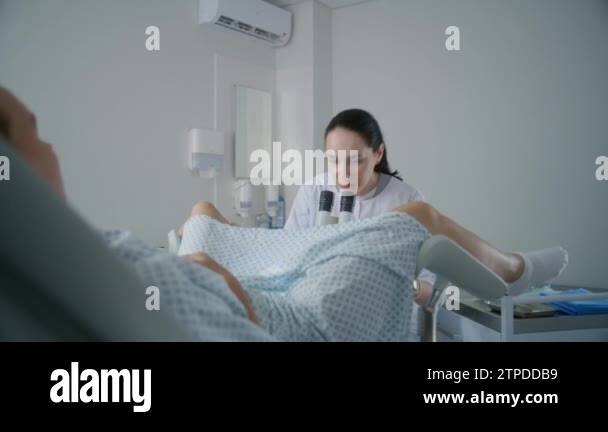 Gynecology room in hospital. Female gynecologist uses colposcope, takes ...