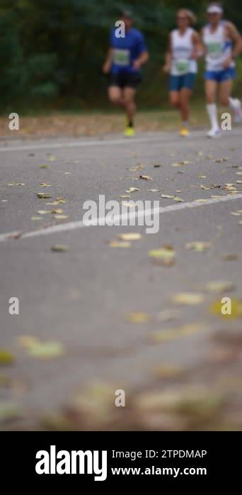 Vertical Screen: Slow motion unrecognizable athletes running marathon ...