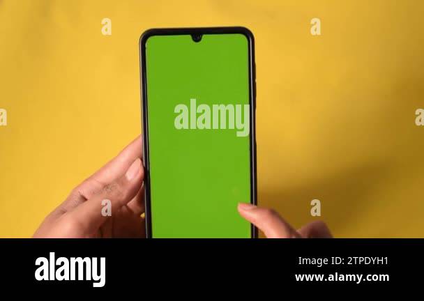two hands hold a smartphone and scrolling the screen, green screen ...