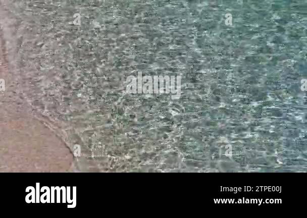 Paradise sea ripple water surface with sunlight glow and pebble bottom ...