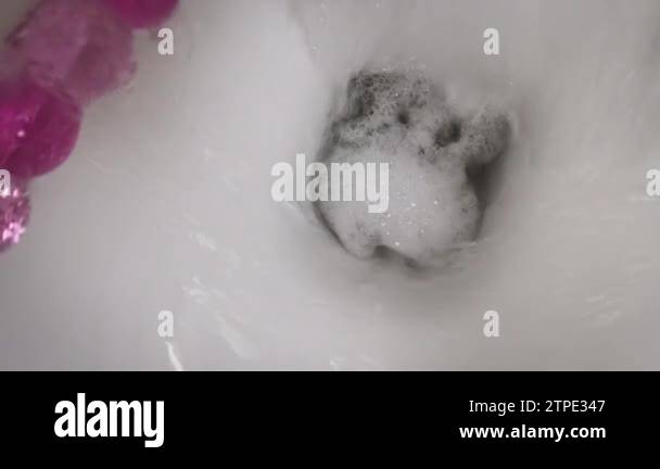 Inside view of flushing water in a toilet in slow motion with rotation ...