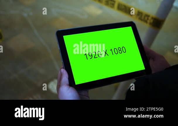 Crime Scene Investigator holding an tablet with green screen at an ...