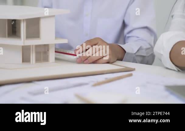 Professional male engineer measure house model by using ruler while ...
