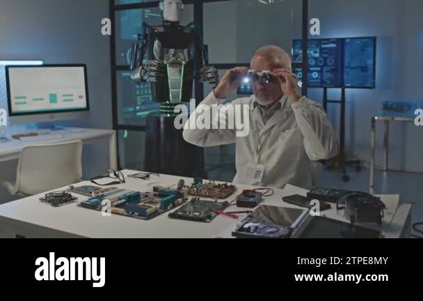 Medium shot of middle aged Caucasian male electronics engineer putting ...