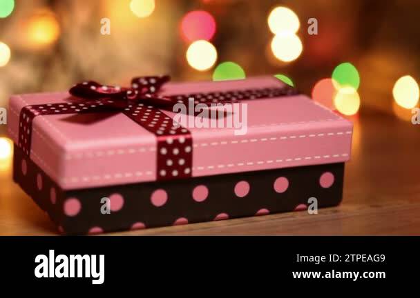 Close up of present box bandaged black ribbon with pink spots on ...