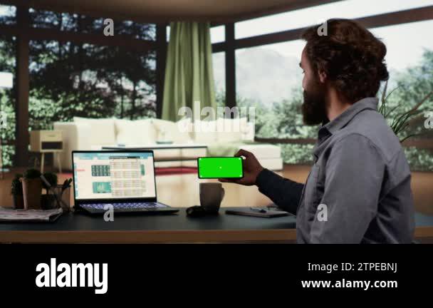 Wealthy businessman checks greenscreen on mobile phone layout, working ...