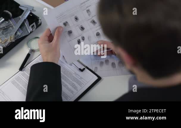 Detective watching fingerprints on paper, using magnifying glass ...
