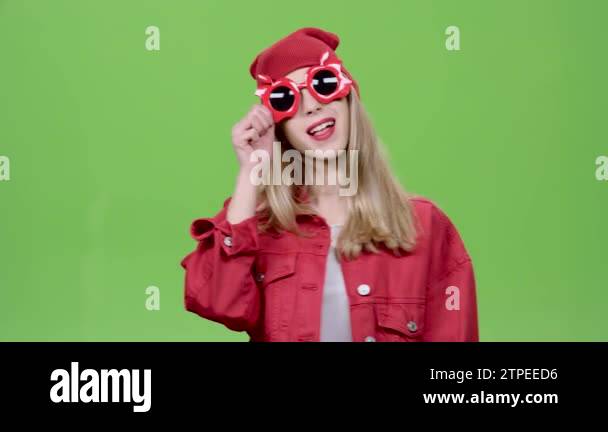 Teenager in funny glasses builds grimaces, winks and shows the language ...