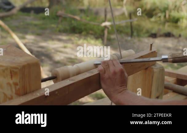 The carpenters hands carve a shape with a cleaver tool from a wooden ...