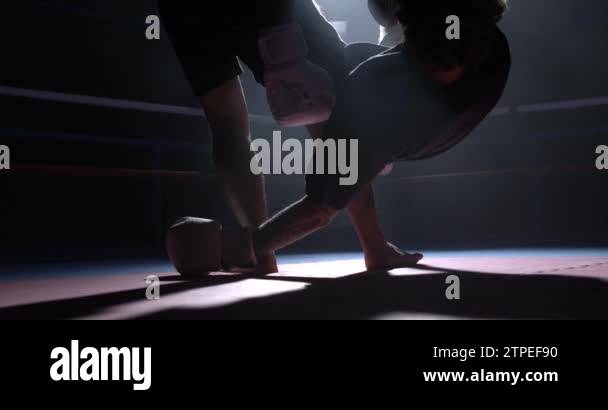 Dramatic fighting takedown in speed-ramp slow motion inside boxing ring ...