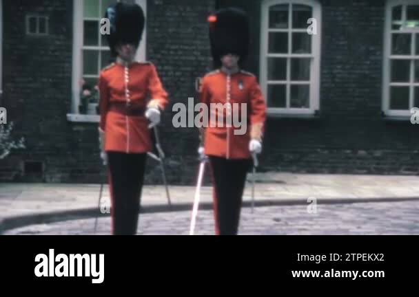 Two Coldstream Guards marching with swords in their right hands ...
