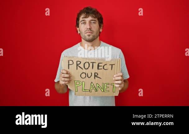 Nervous young man holding 'protect our planet' banner. skeptic ...