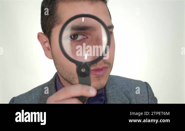 Young businessman looking through magnifying glass. Business emotions ...