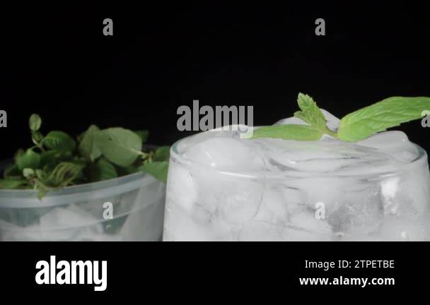 A container of mint and a glass of soda on the table. mint leaves on ...