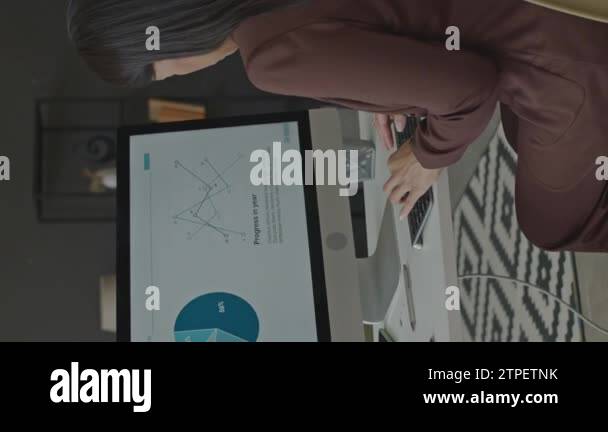 Vertical back view shot of young Biracial woman typing on keyboard ...