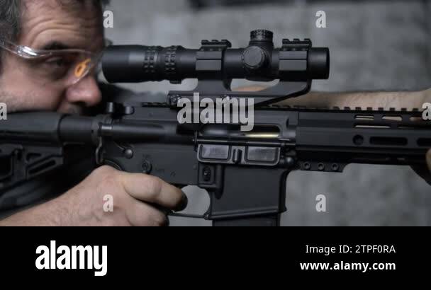Shooting a single shot with an assault rifle detail close-up of finger ...