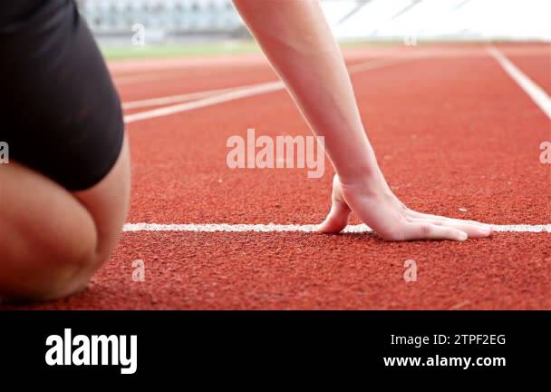 Track runner boy teenager preparing to run at starting line, legs and ...