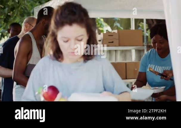 Friendly volunteers offering hunger relief to poor and needy ...