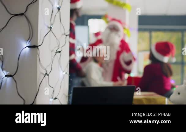 Revealing shot of manager dressed as Santa in festive ornate office ...