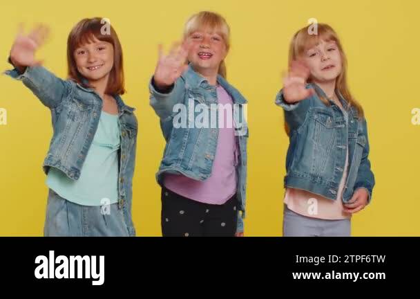 Teenage girls smiling friendly at camera and waving hands gesturing ...