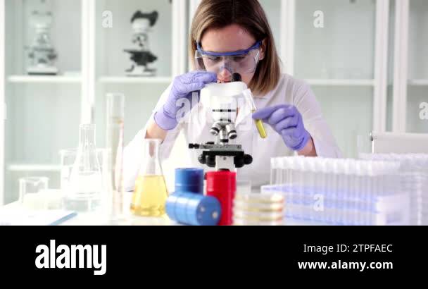 Scientist examining sample of petroleum products under microscope ...