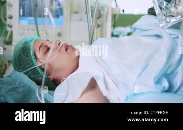 Close-up of the patient during surgery. An African-American woman lies ...