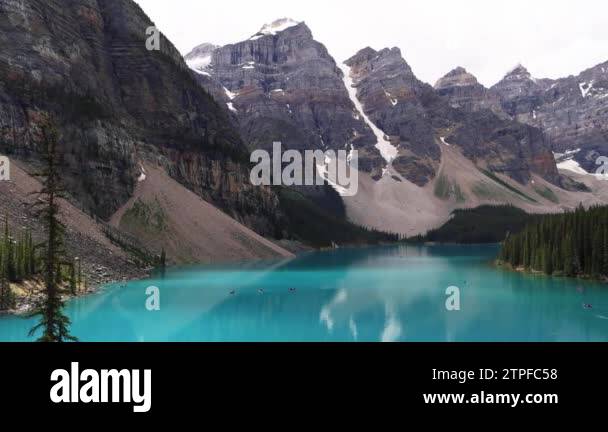 Looking our over the bright blue glacial water of Moraine Lake with ...