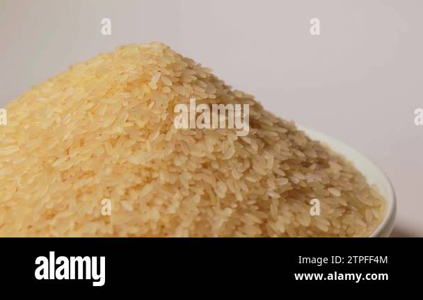 Dry Uncooked Parboiled Rice Heap Rotating against White Background. A ...