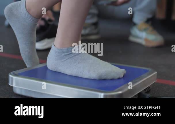 School children undergo together weight evaluation in sports gym with ...