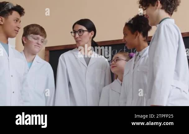 Medium shot of joyful Caucasian female teacher of Chemistry and group ... Medium shot of joyful Caucasian female teacher of Chemistry and group ...