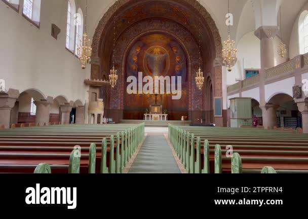 The interior of a church with a vaulted wooden ceiling and beams. The ...