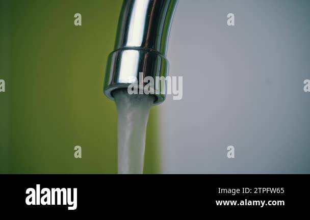 Close-up of water flowing from a kitchen faucet. drinking water from ...