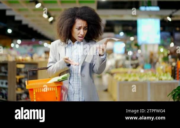 Woman shopper takes out a paper check in a grocery store in supermarket ...