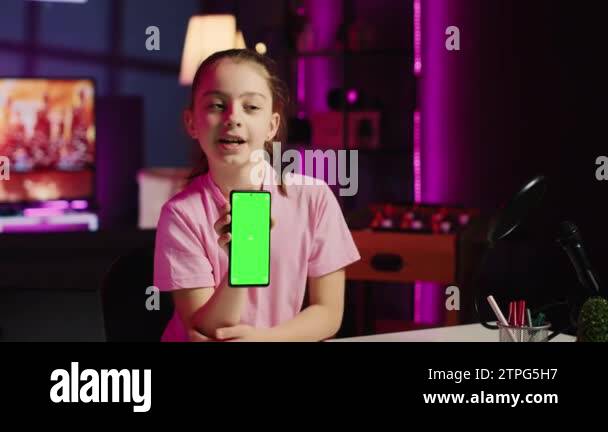 Kid content creator filming technology review of newly released green ...