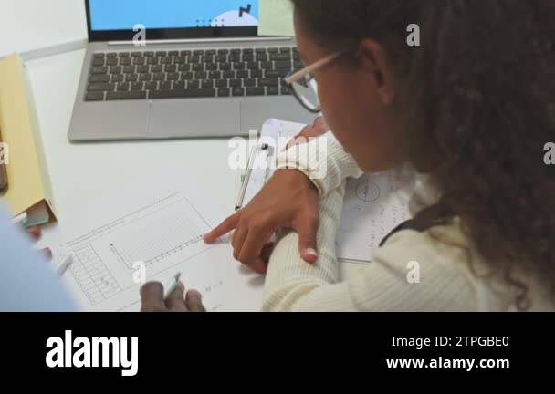 Over the shoulder of Black male teacher explaining Math to African ...