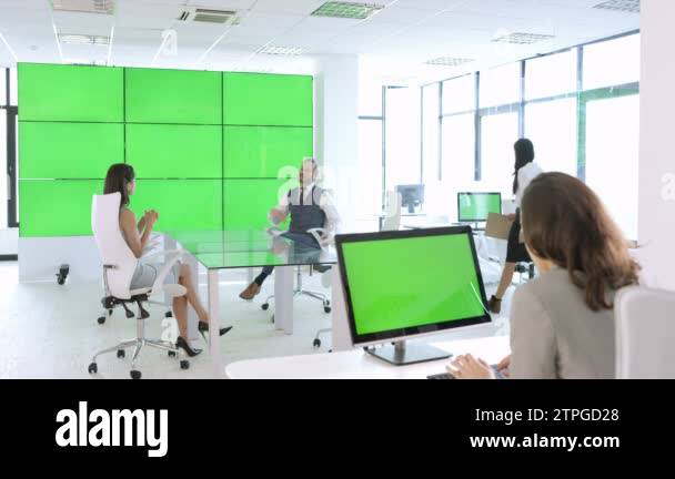 4K Business team in modern office green screen on video wall and ...