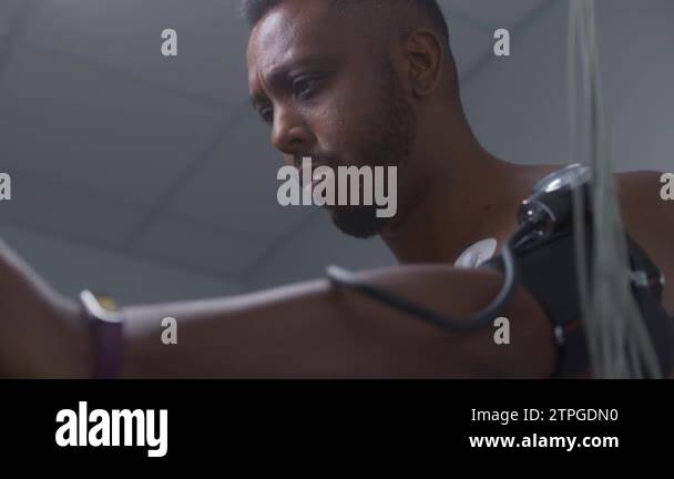 African American man with tonometer and sensors pedals orbitrek in ...