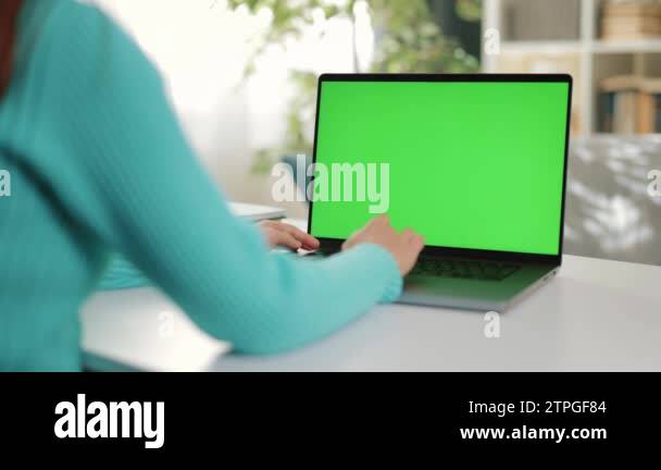 Womans hands operate laptop computer on desk at home using touchpad and ...