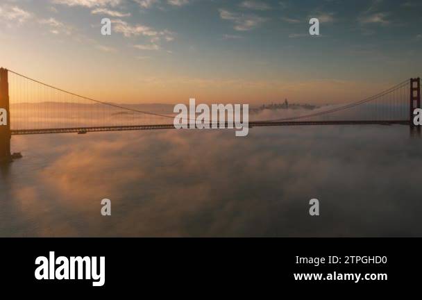 Cinematic aerial red Golden Bridge silhouette with modern downtown San ...